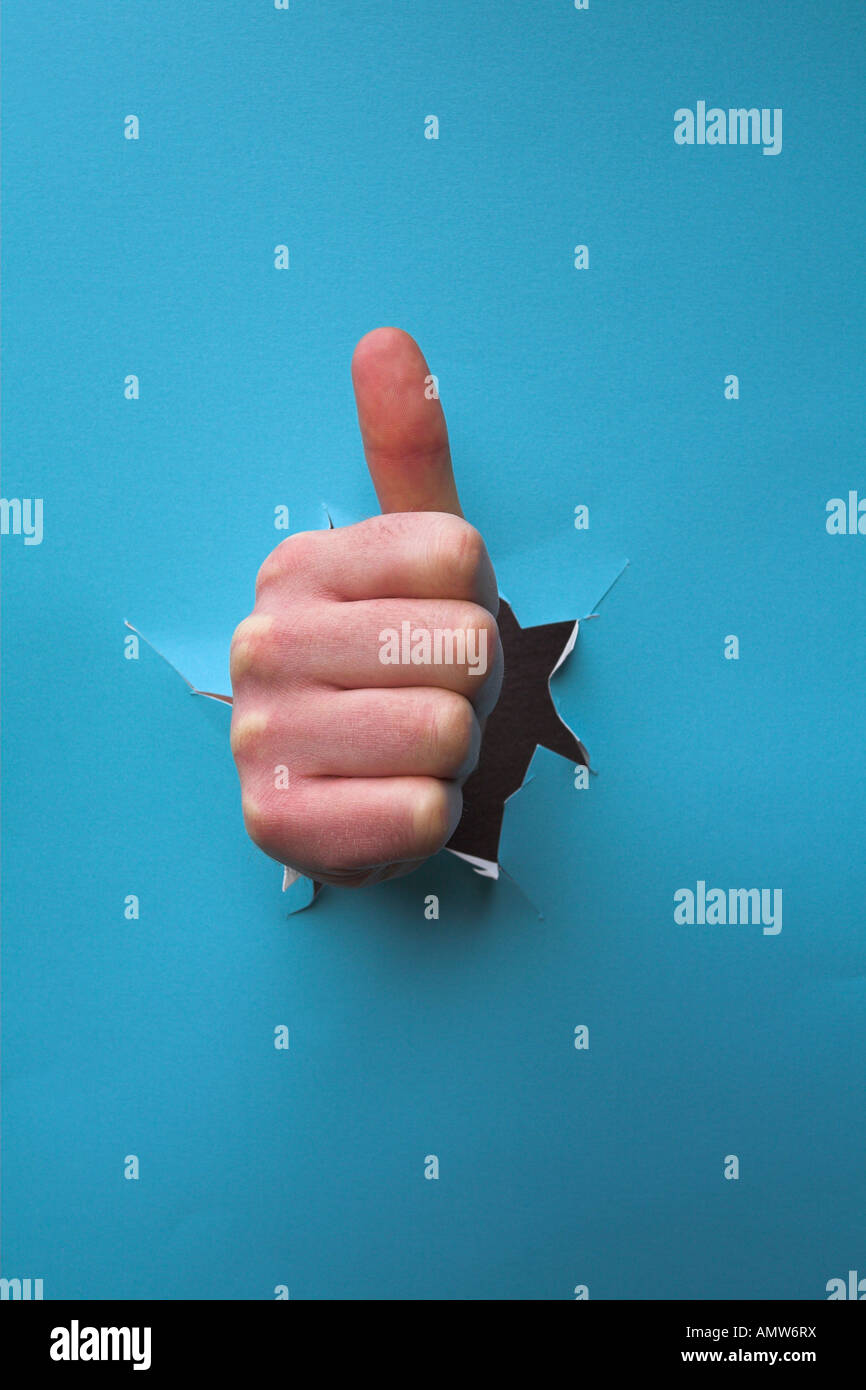 Thumbs up hand sign isolated on a blue background Stock Photo - Alamy