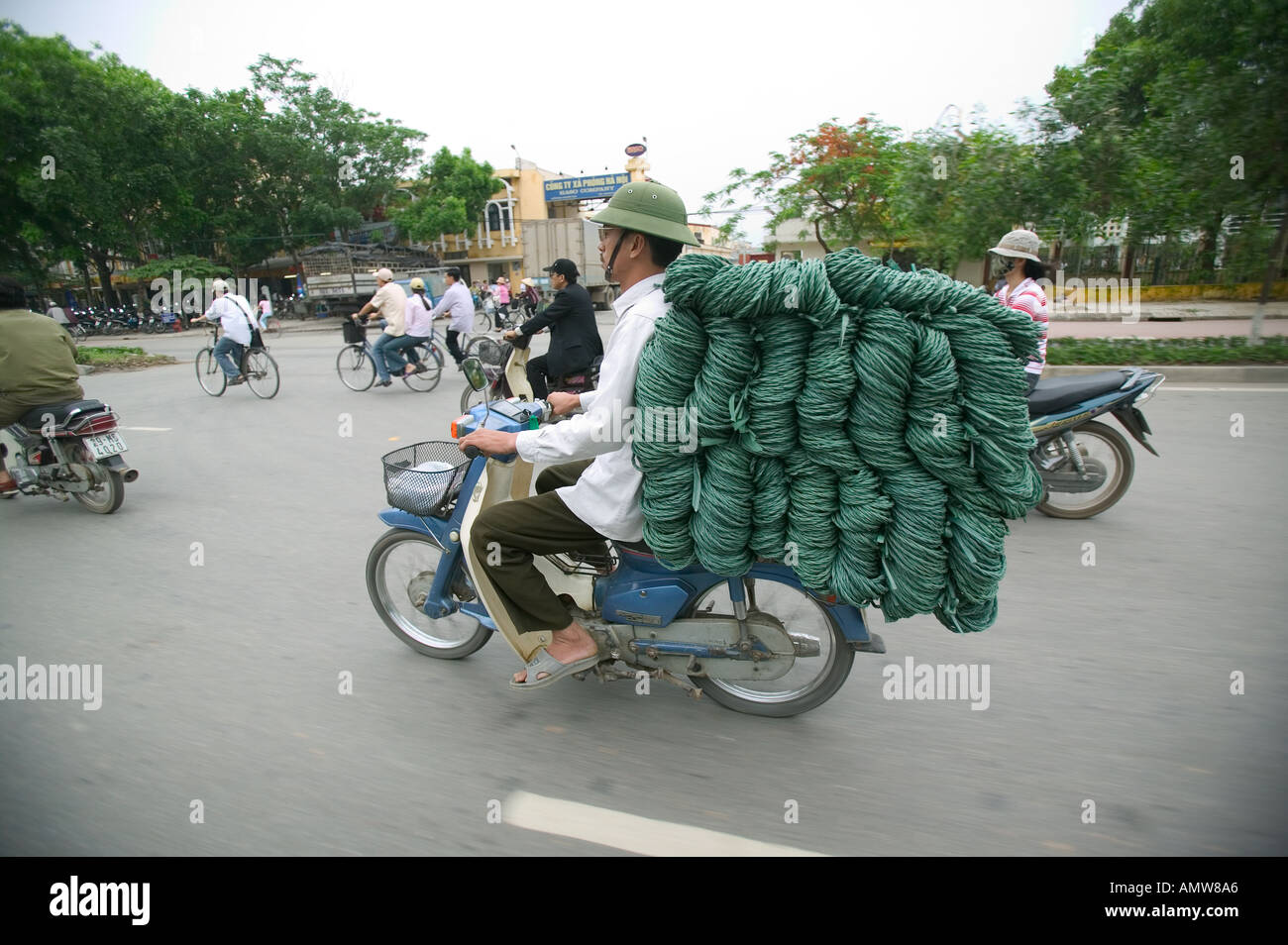 Motorcycle taxi with cargo of coloured jute rope in busy traffic in ...