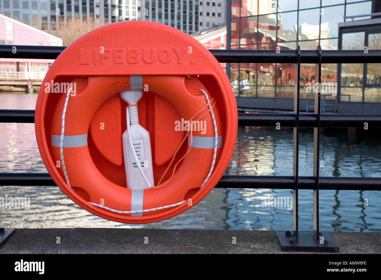 Red lifebouy safety equipment on railings near water Stock Photo - Alamy