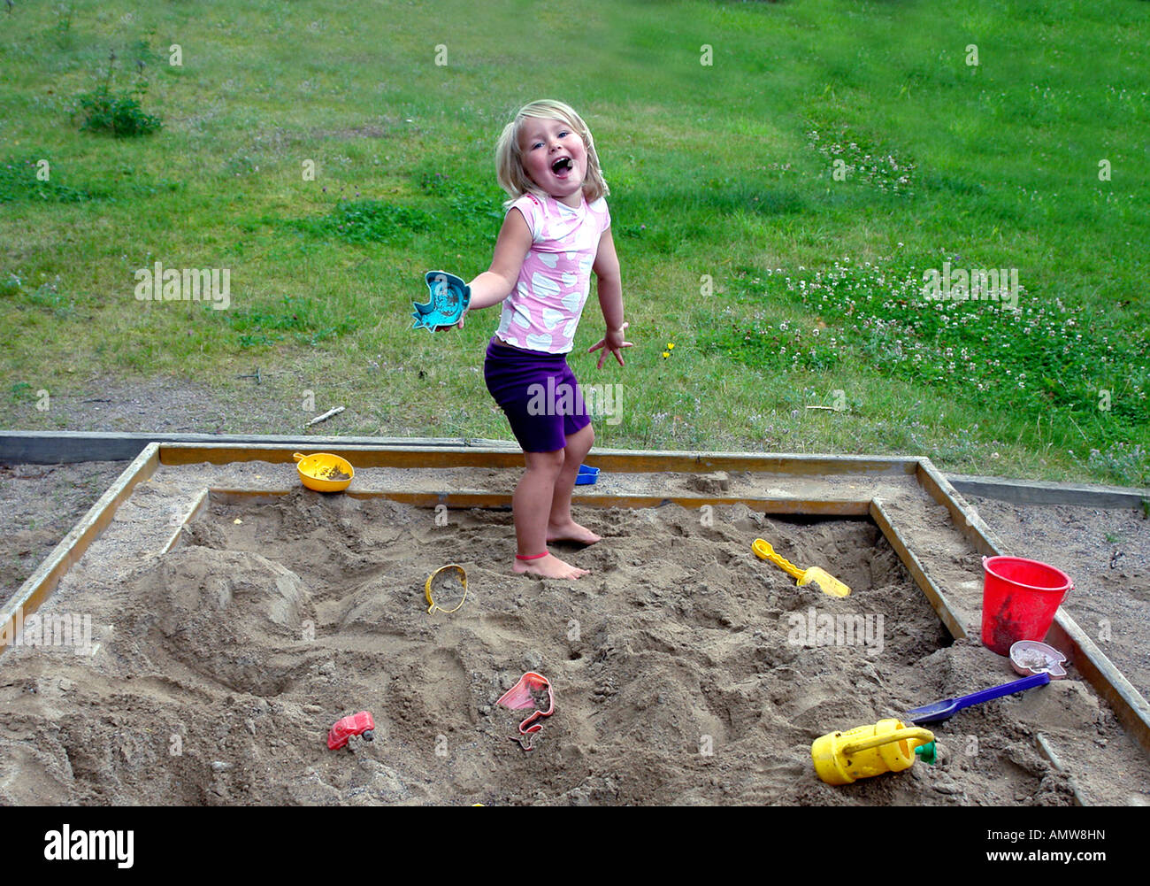 Happy girl in the sandbox Stock Photo - Alamy