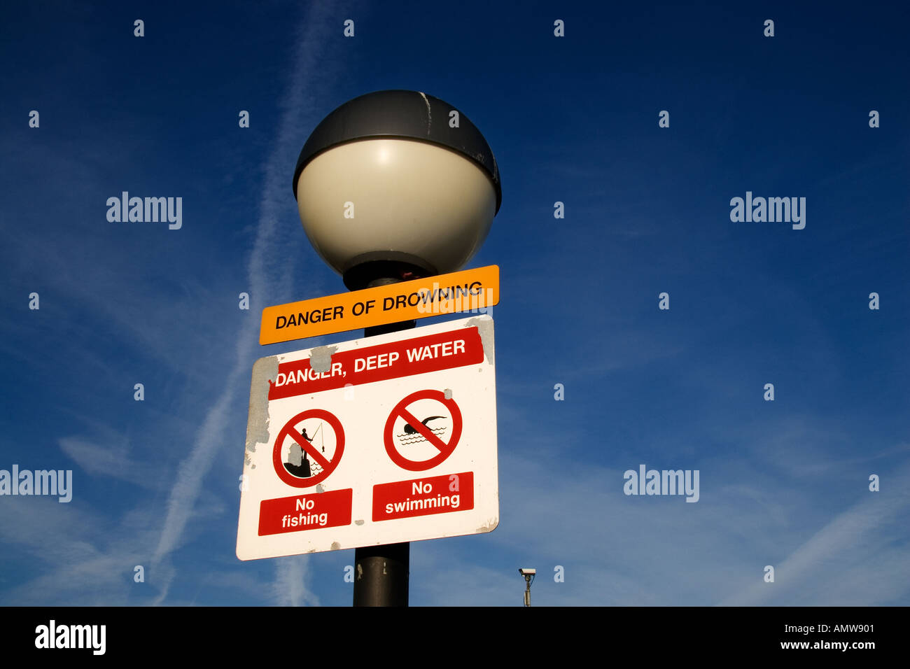 Signpost with yellow and red danger deep water warning with a deep blue ...