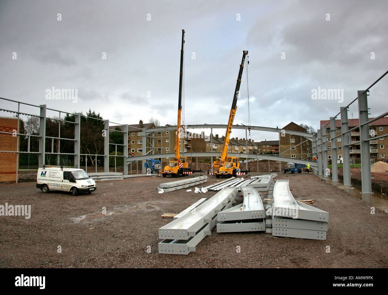 Cranes lifting steel beams on construction site Stock Photo - Alamy