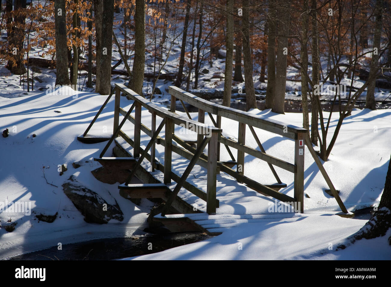 Snow covered footbridge over a stream Stock Photo - Alamy