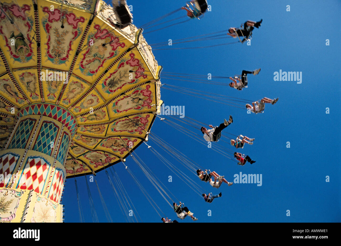 Giant merry go round with people in slung seats Stock Photo - Alamy