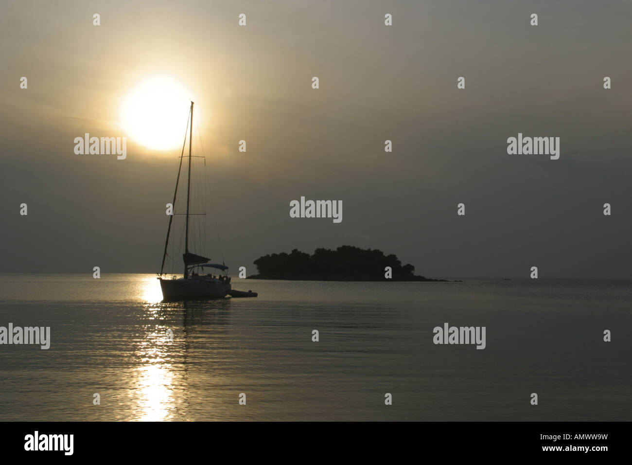 A Sailing Boat with Misty Sunset and Reflection on Water Stock Photo ...