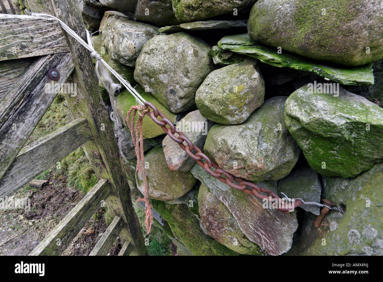 Rusty old chain on stone wall Stock Photo - Alamy