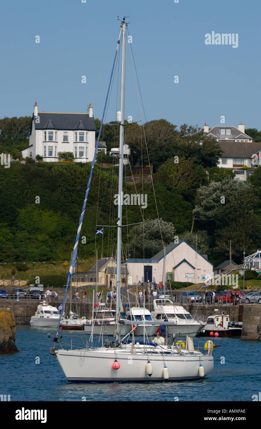 White yacht leaves Portpatrick harbour female skipper Stock Photo - Alamy