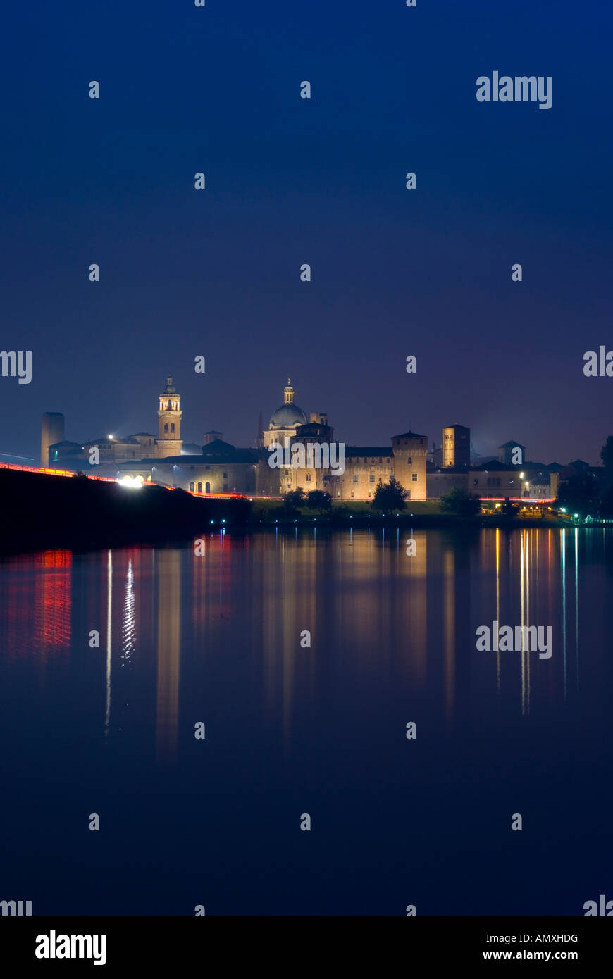 Reflection of lit up buildings in water at night, Lago Di Mezzo, Mantua ...