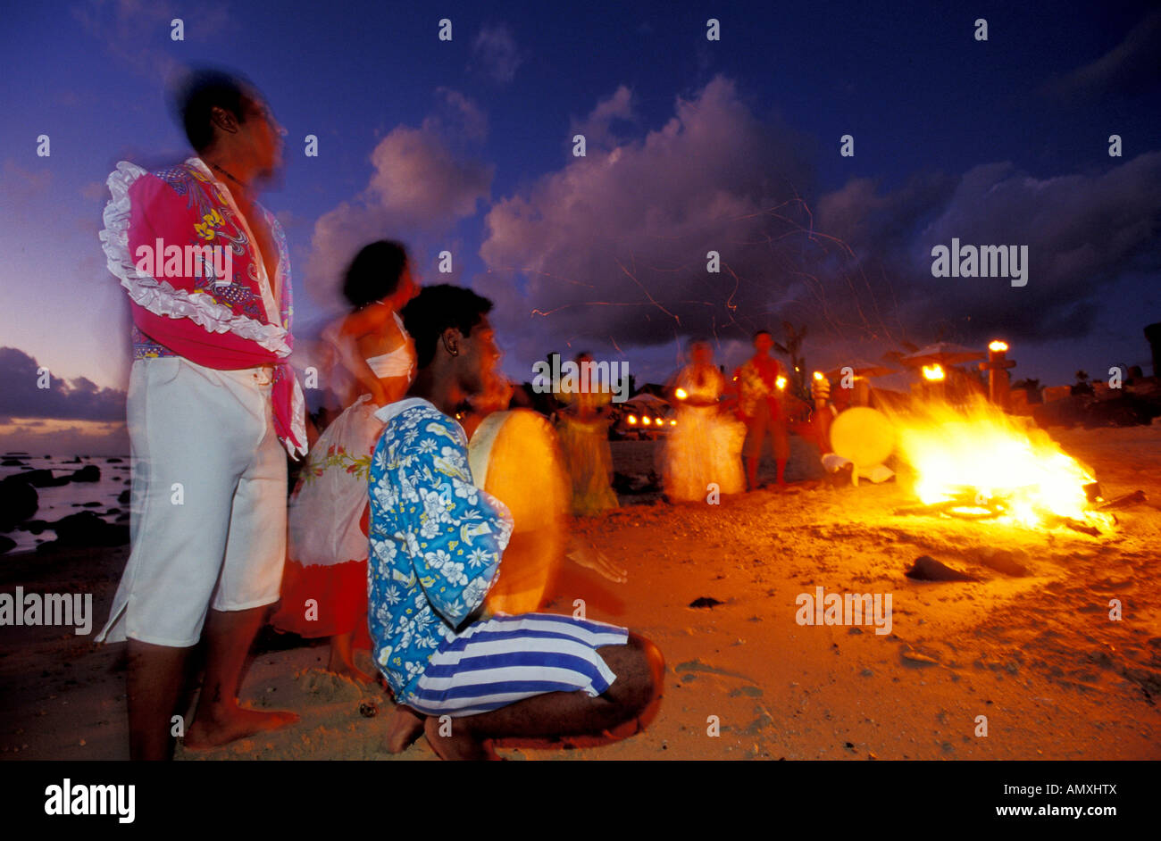 Group of people playing music and dancing around bonfire Mauritius ...
