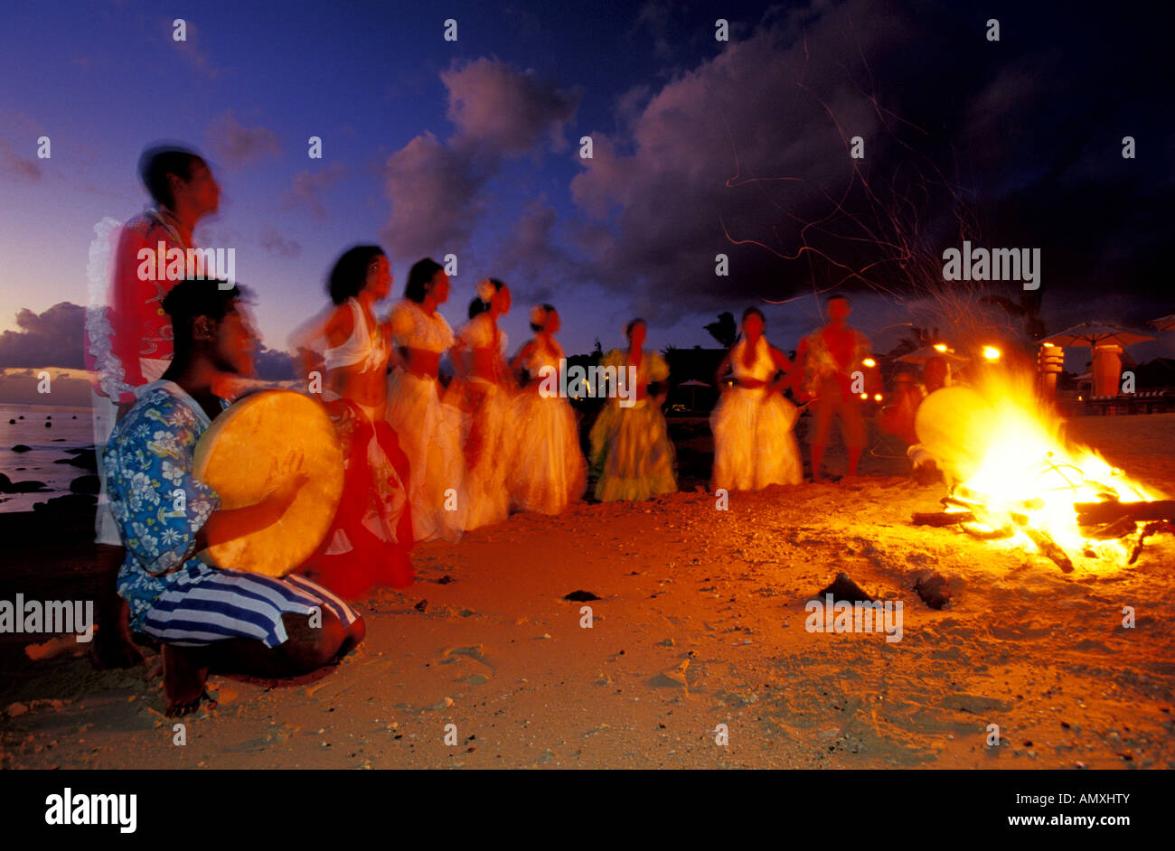 Group of people playing music and dancing around bonfire Mauritius ...