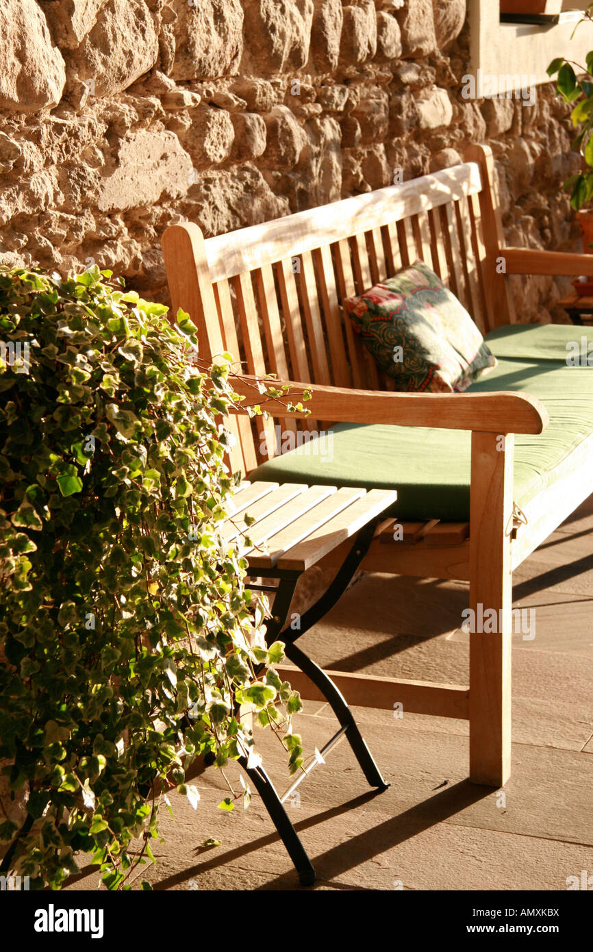 Empty bench in front of stone wall Stock Photo - Alamy