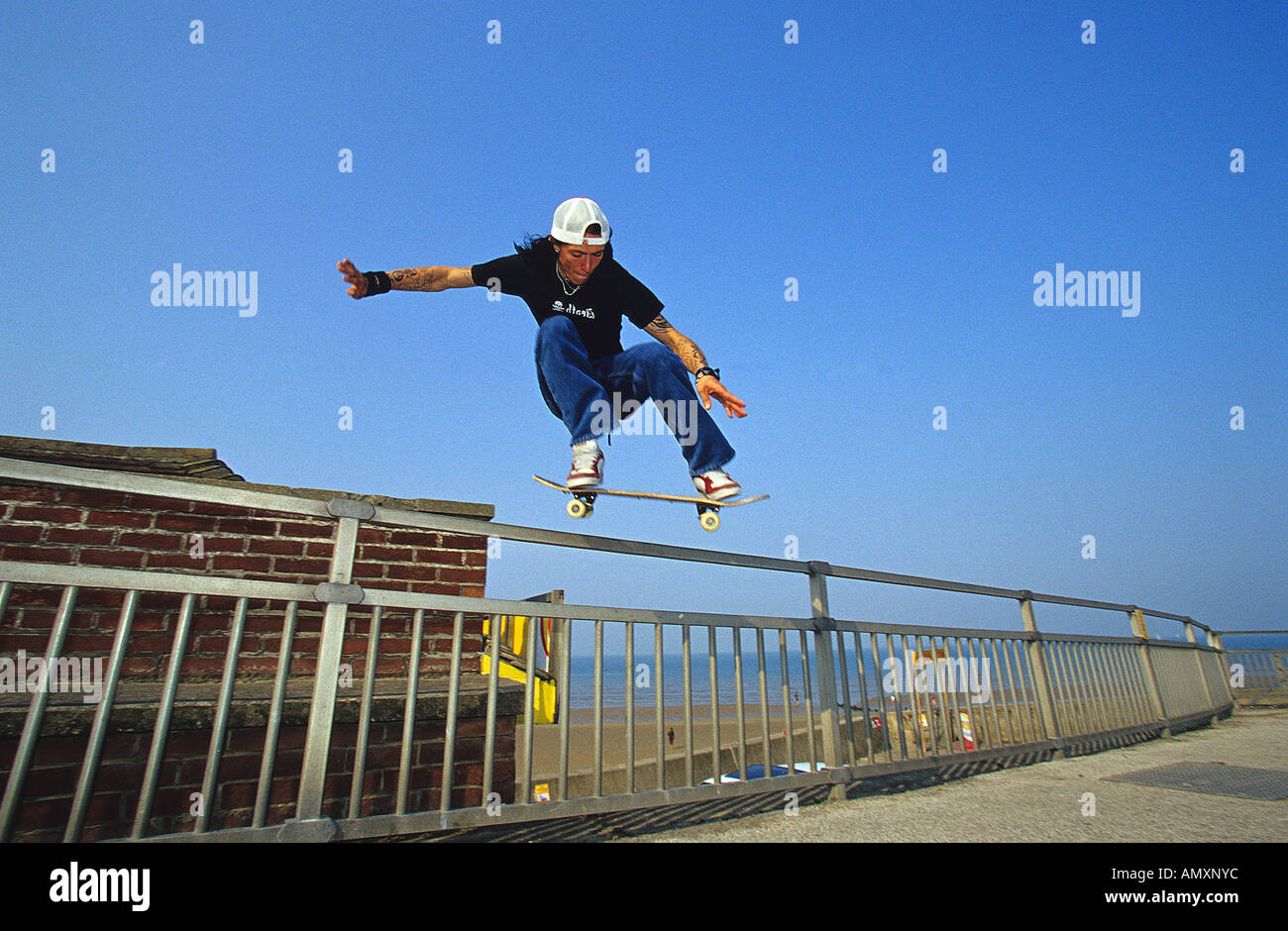 Skateboarder jumps rail Stock Photo - Alamy