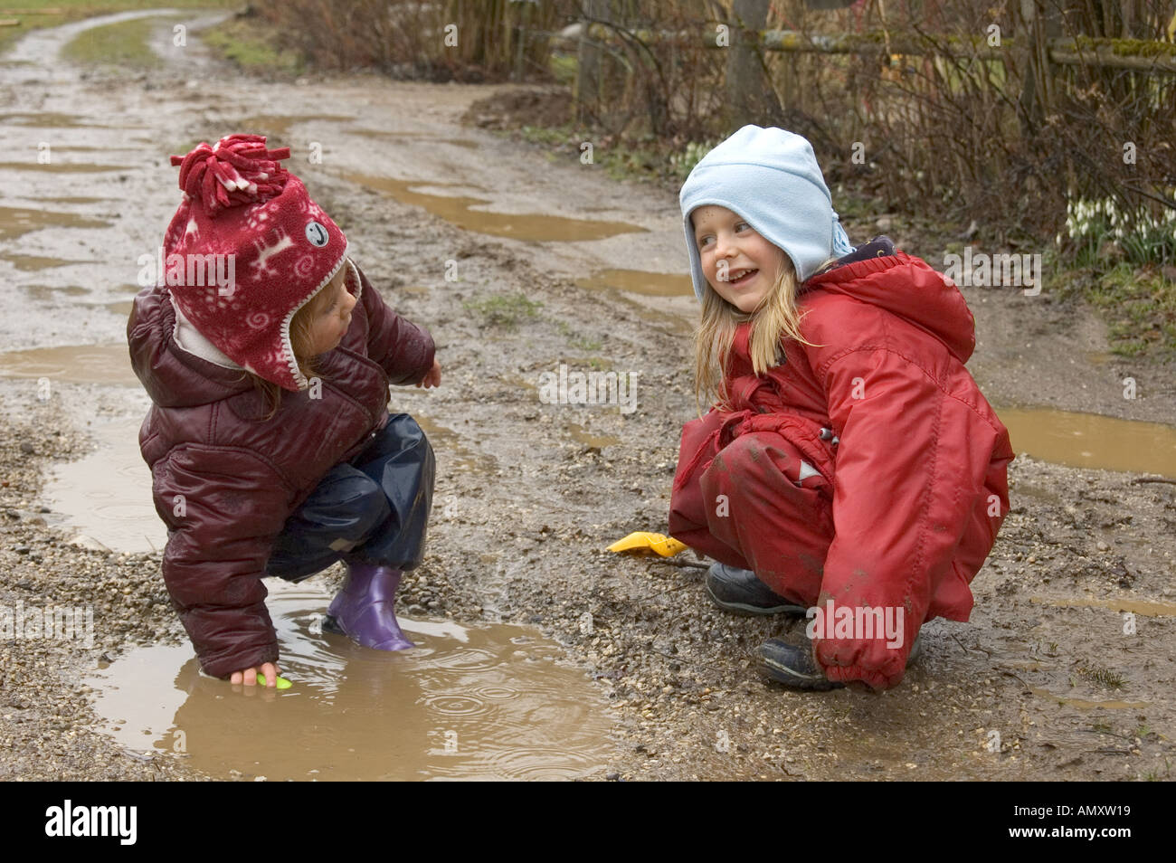 MR Children are playing during bad weather and rain in puddle and mud ...