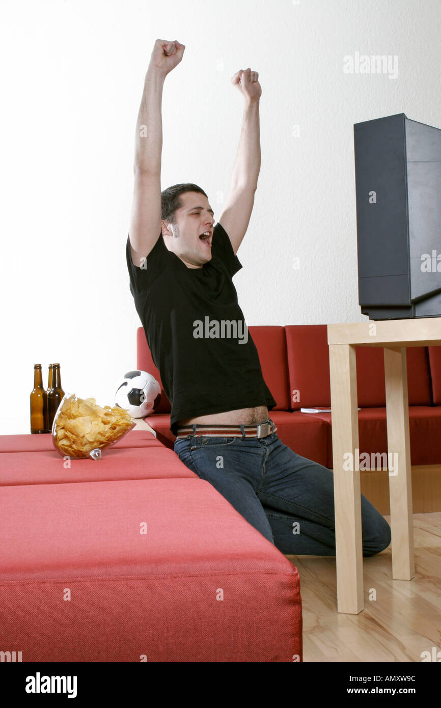 Man relaxing on sofa watching football Stock Photo - Alamy