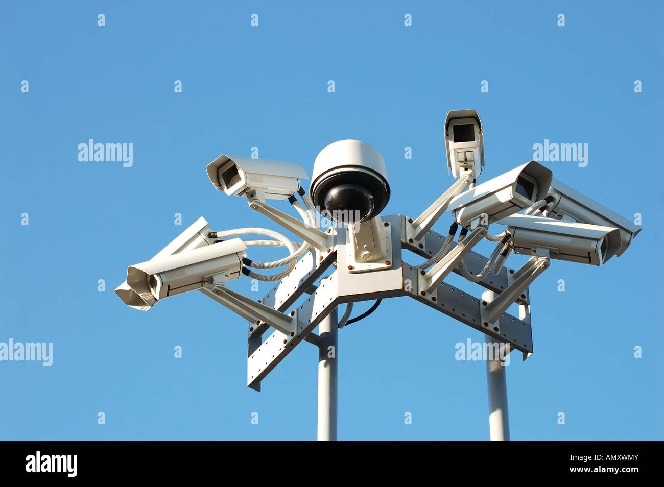 Security cameras mounting on the high top position against a clear blue ...