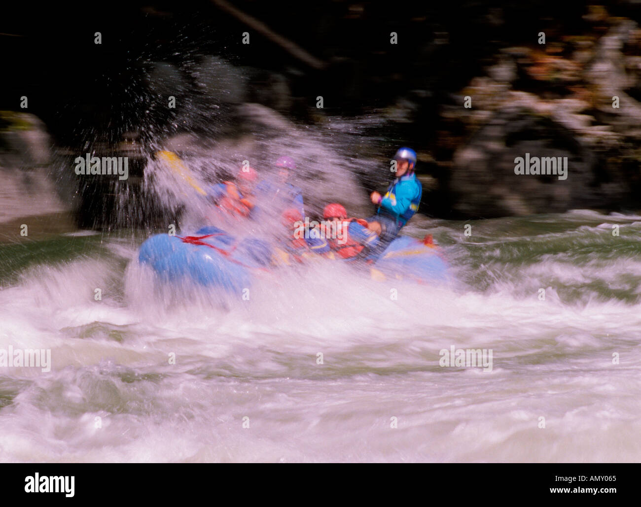 River rafters blast through a wave in a rough stretch of river in ...
