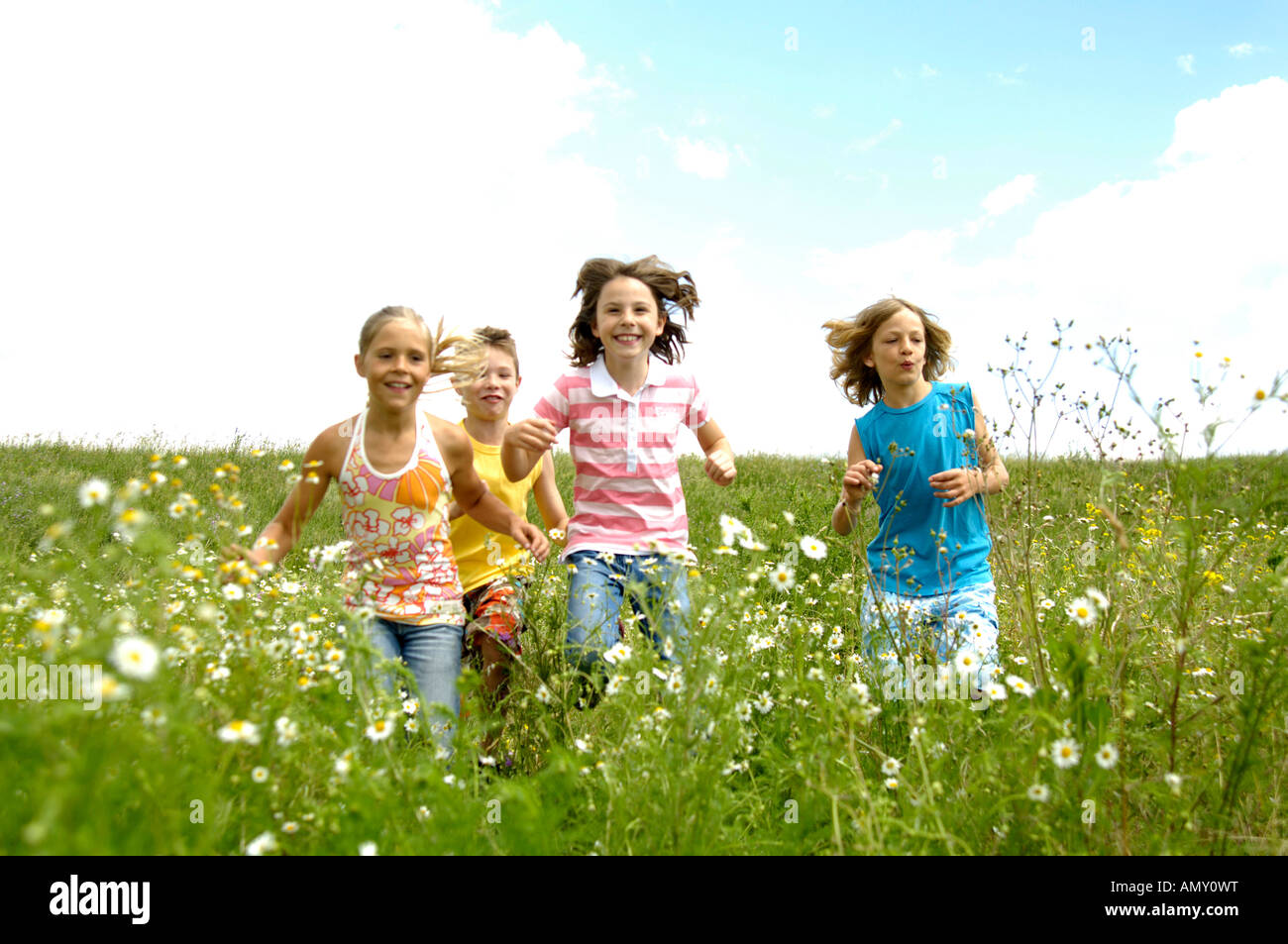 four children playing in field Stock Photo - Alamy