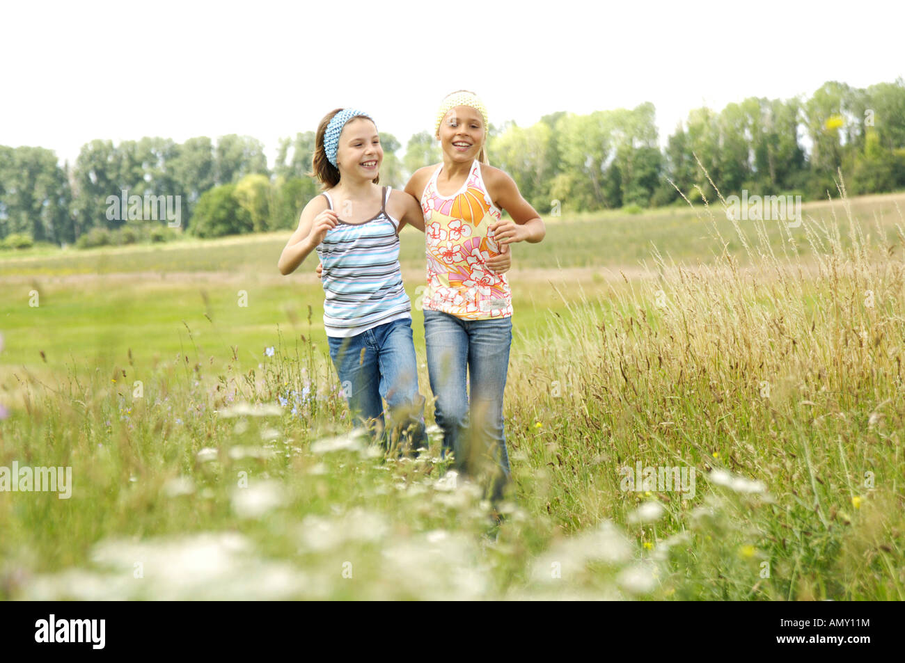 Two girls running in field Stock Photo - Alamy
