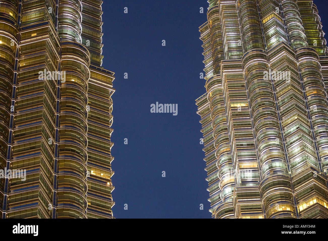 Twin skyscrapers in city lit up at dusk, Petronas Towers, Kuala Lumpur ...