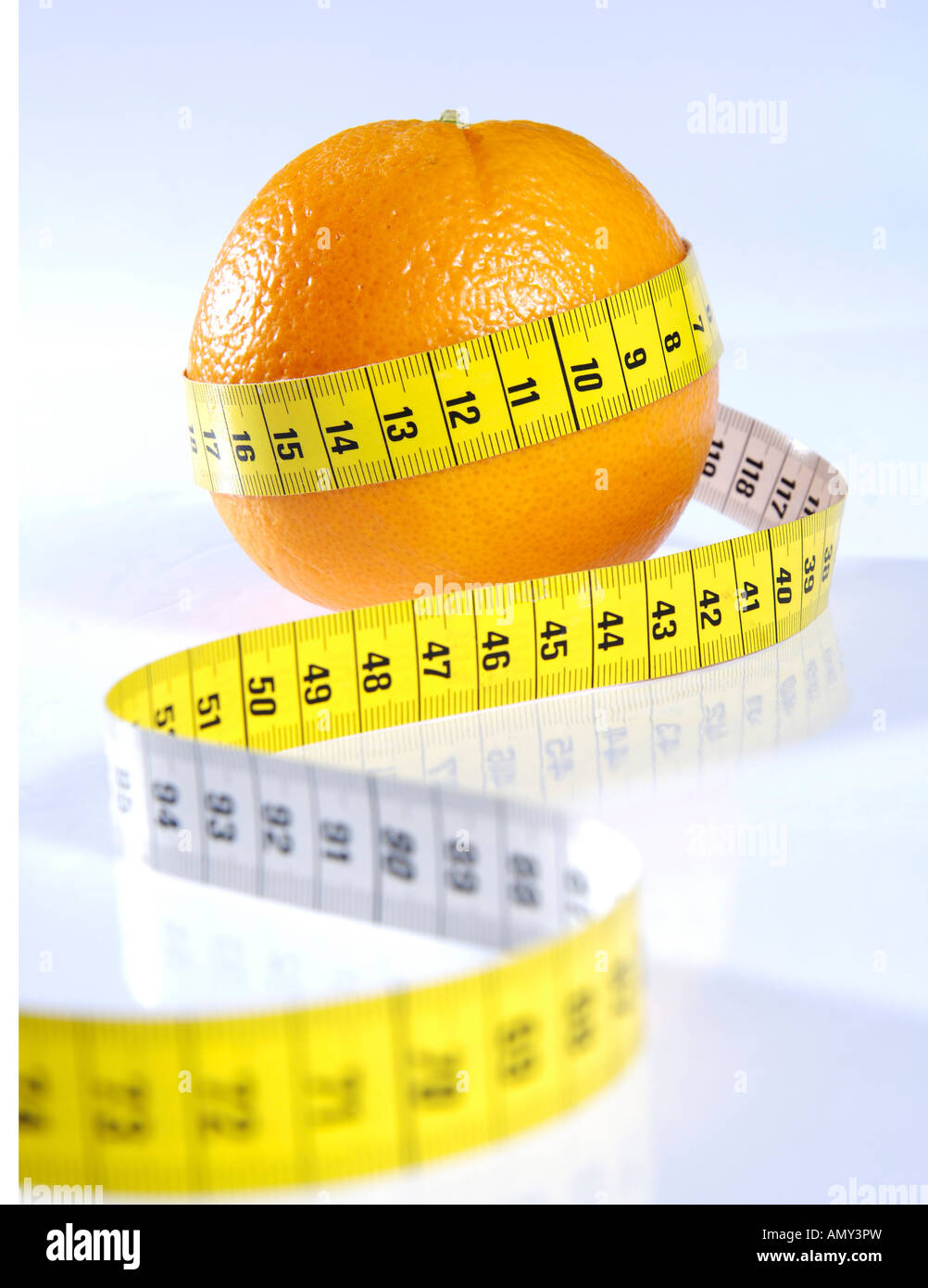 Measuring tape wrapped around orange Stock Photo - Alamy