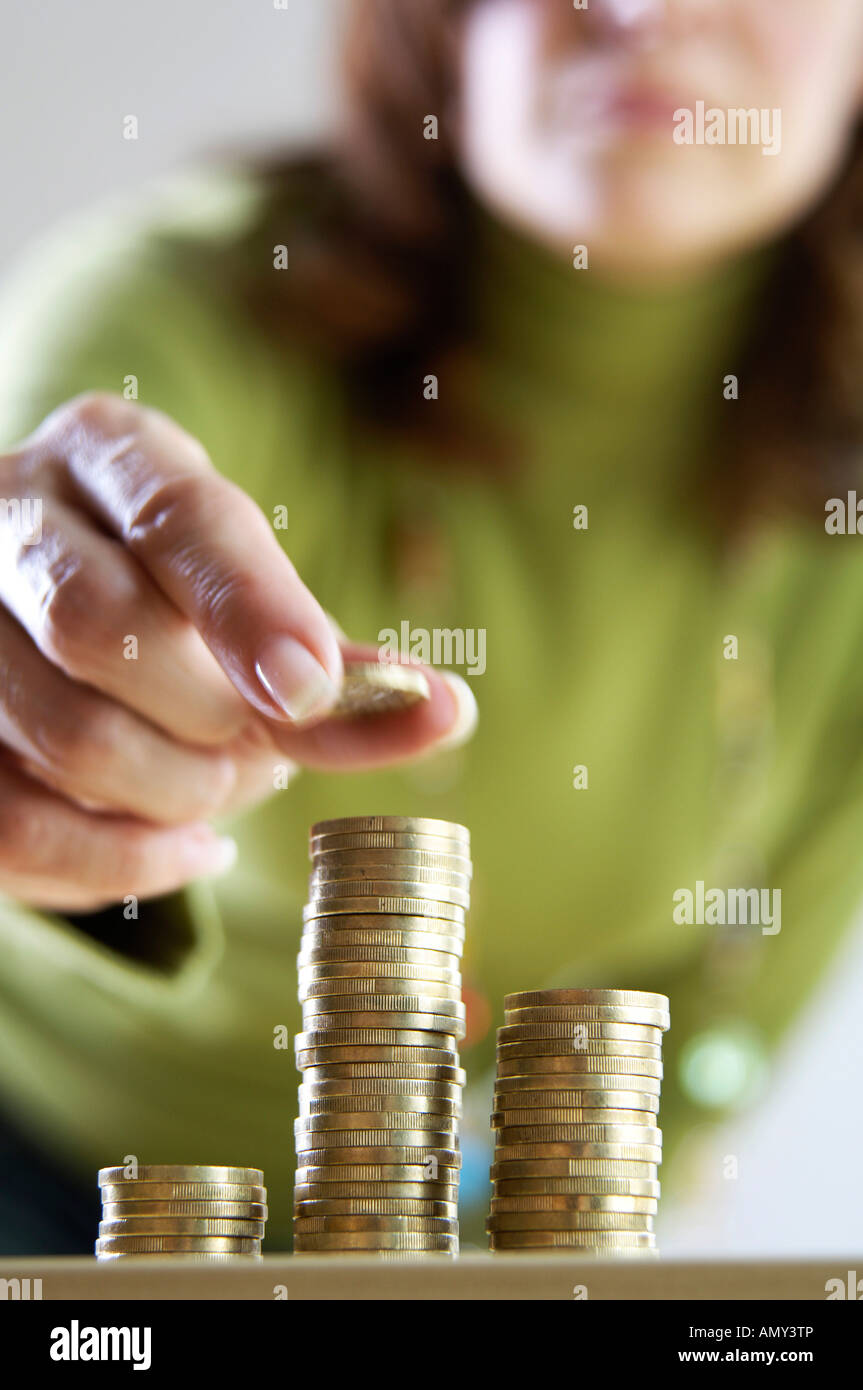 Woman stacking coins Stock Photo - Alamy
