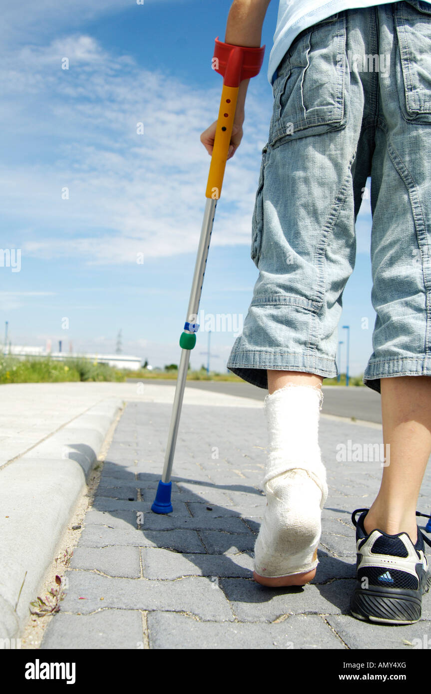 Low section view of boy walking on road with broken leg Stock Photo - Alamy