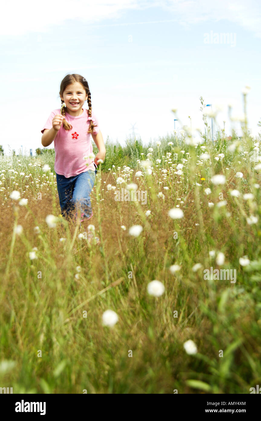 Girl running in field and smiling Stock Photo - Alamy