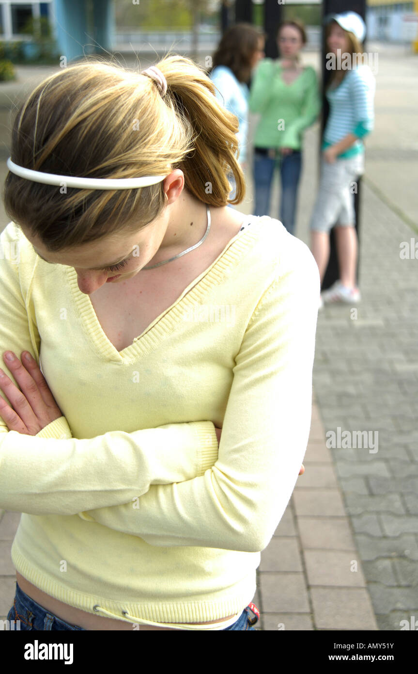 Close-up of teenage girl looking sad with her friends standing in ...