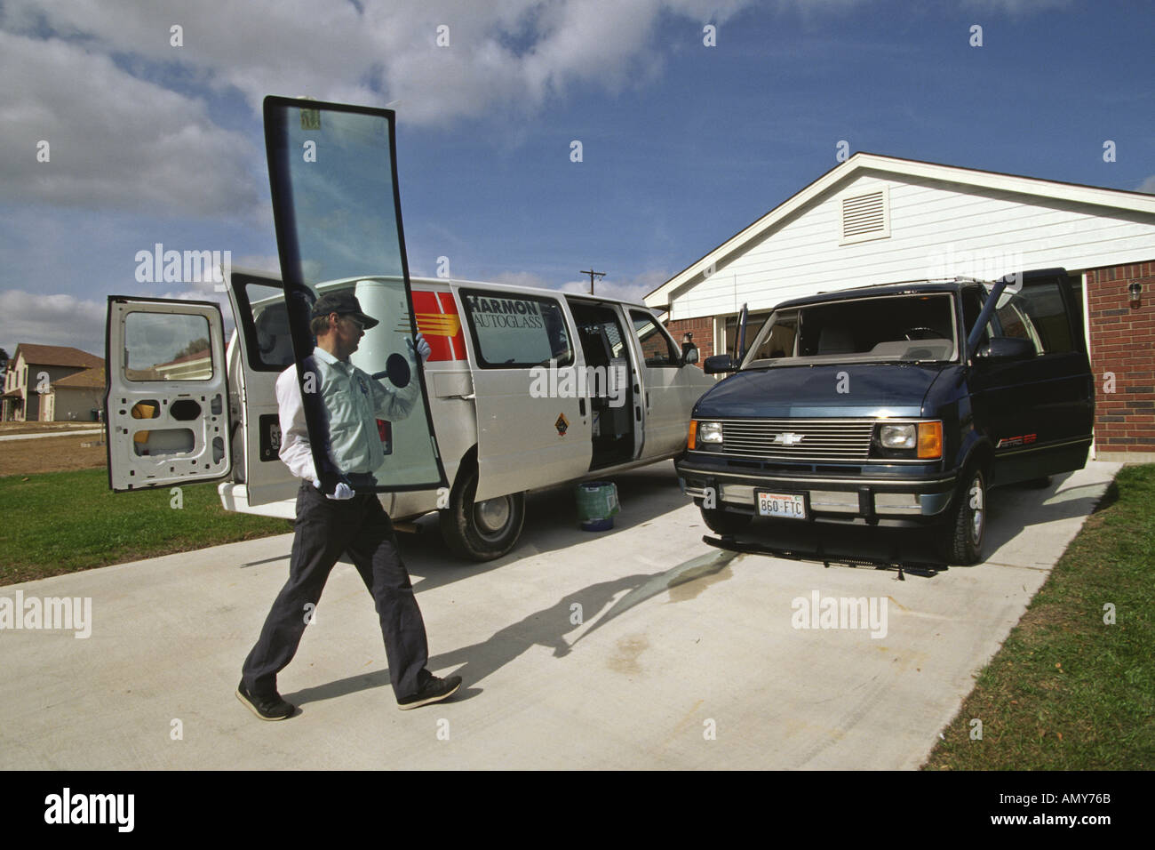 Mobile automotive glass installer carrying new replacement windshield ...