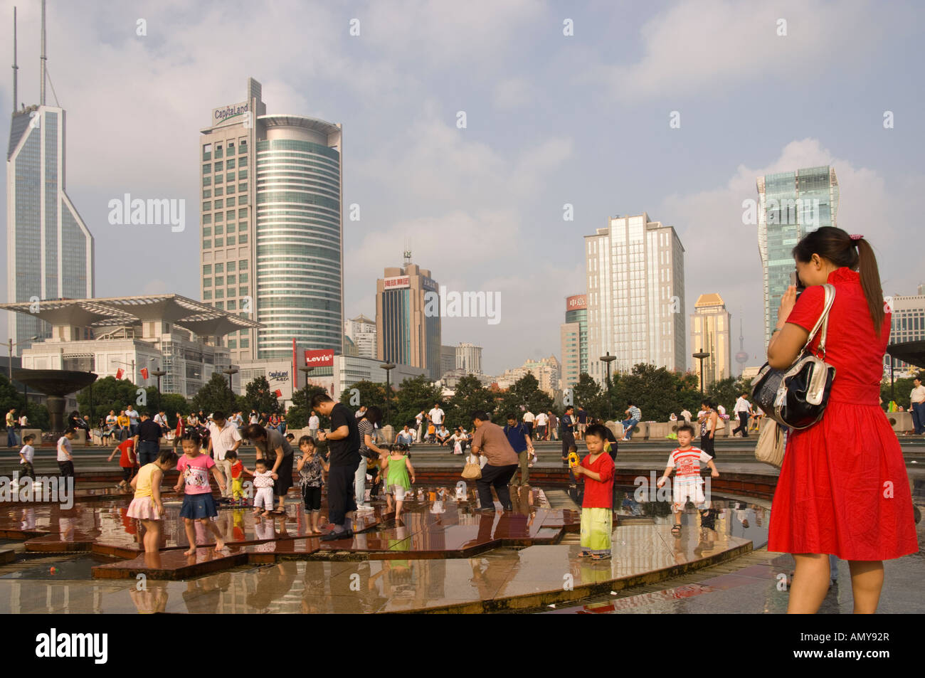 China Shanghai Renmin square area woman in red dress taking a picture ...