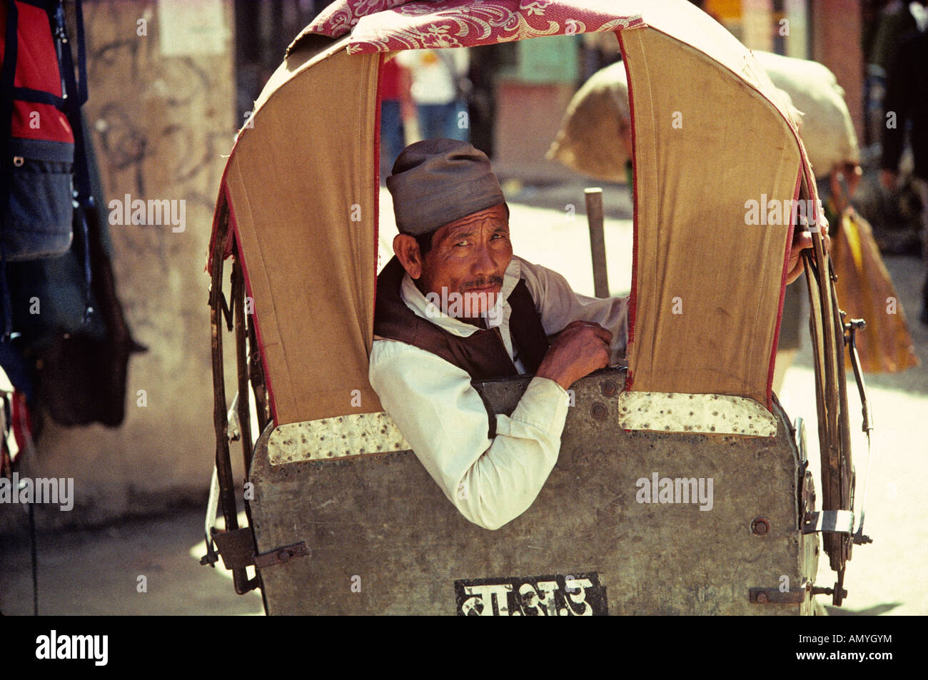 KATHMANDU NEPAL, LOCAL TAXI DRIVER LEANS OUT OF THE BACK OF HIS CANVAS ...