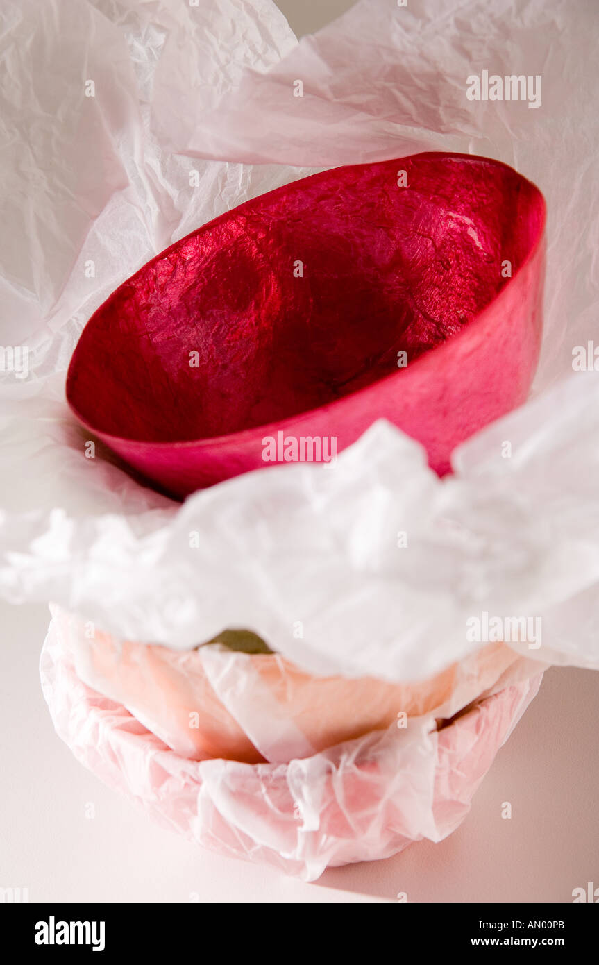 Set of papier-mâché multi-coloured bowls, wrapped in white tissue paper ...