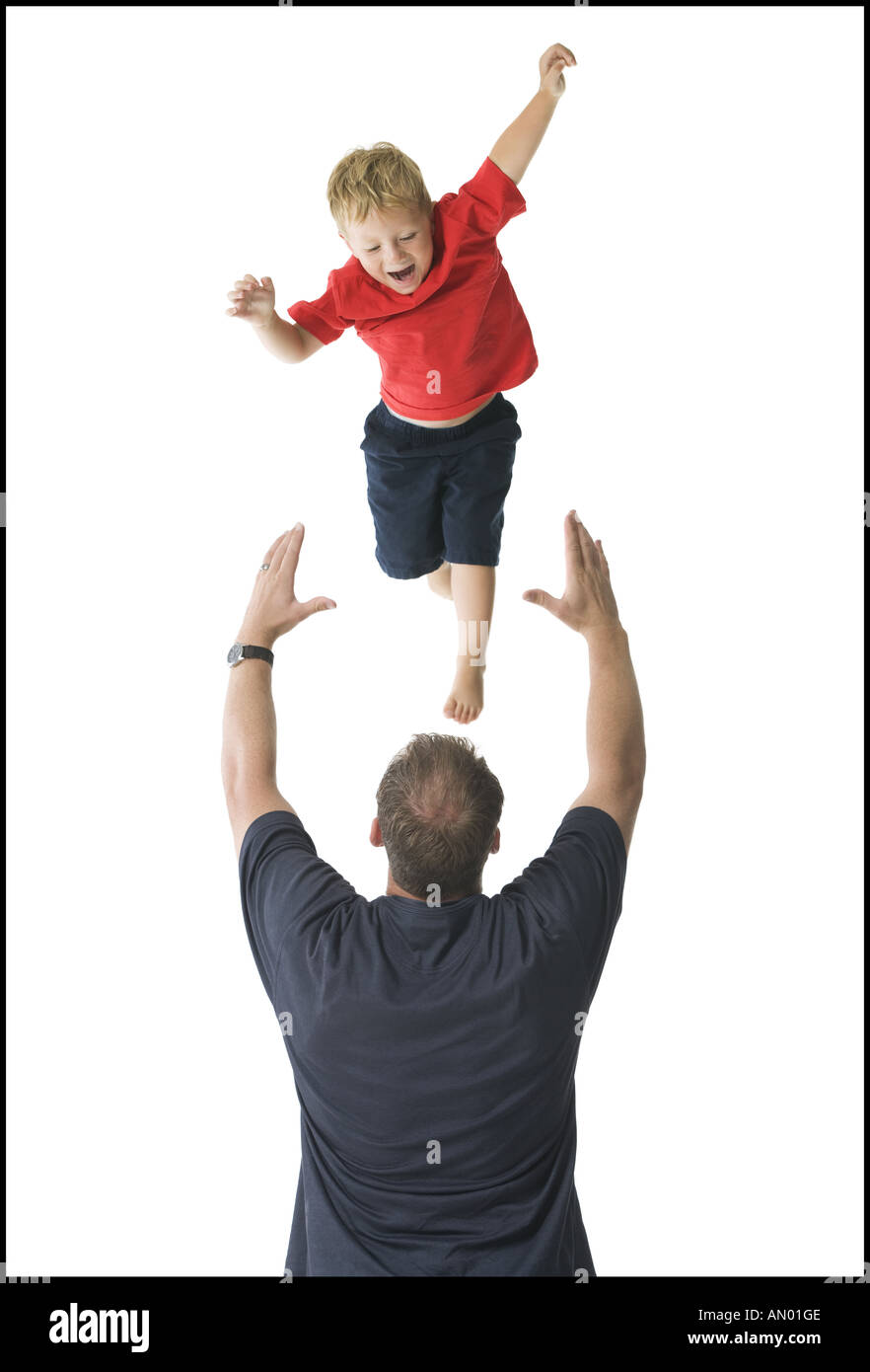 Rear view of a father catching his son Stock Photo - Alamy