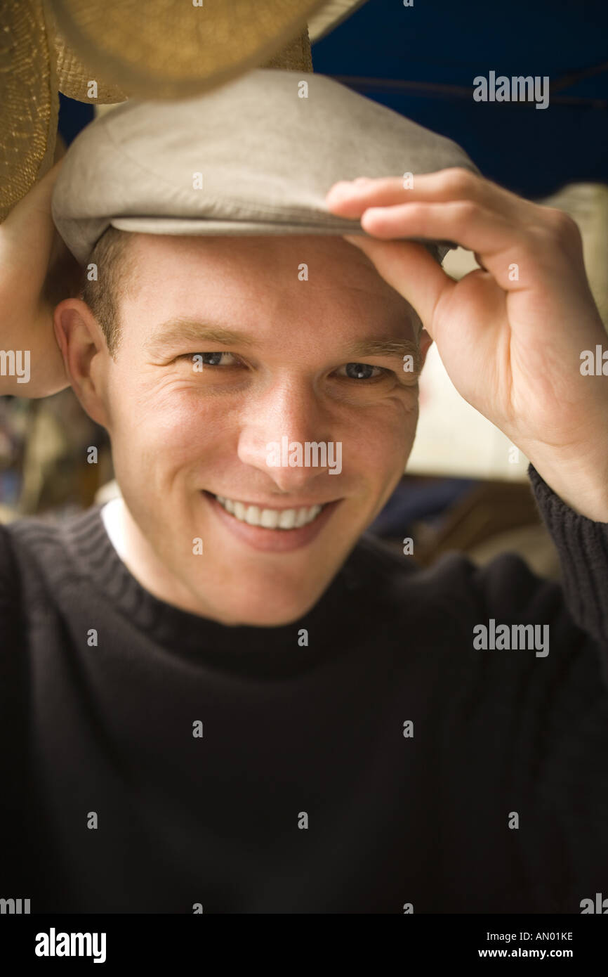 Portrait of a young man adjusting his cap Stock Photo - Alamy