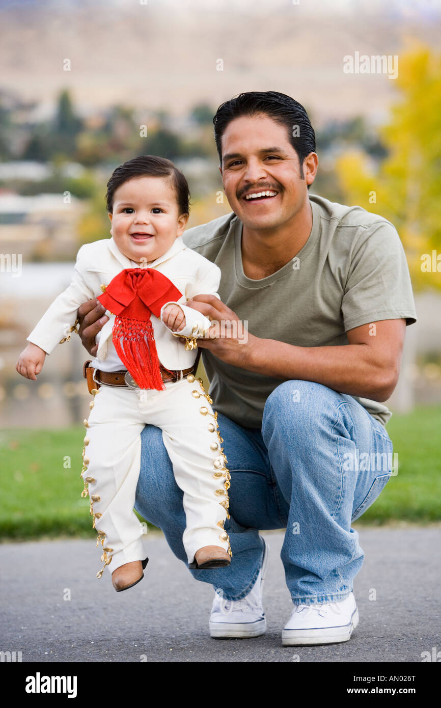 Hispanic father holding baby in costume Stock Photo - Alamy