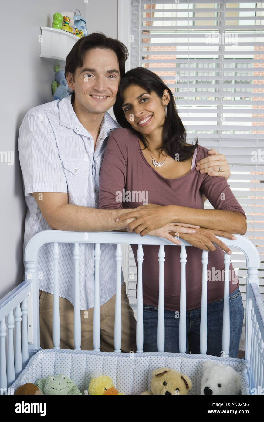 Portrait of a couple leaning on a crib Stock Photo - Alamy