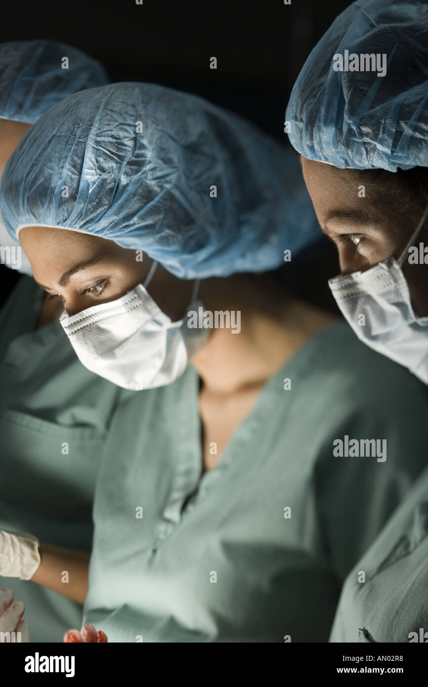 Close up of three female surgeons operating Stock Photo - Alamy