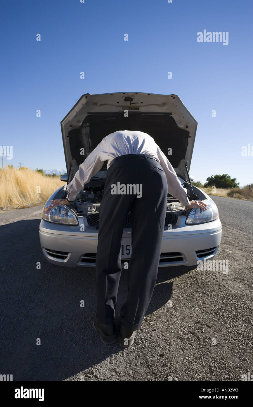 Rear view of a businessman looking at a car engine Stock Photo - Alamy