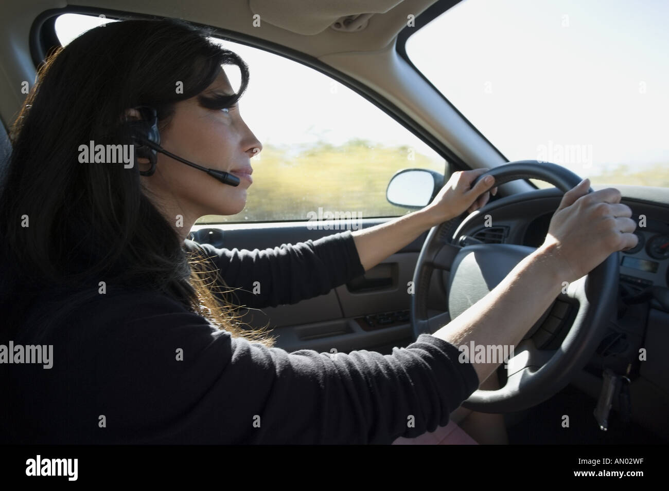 Profile of a woman driving a car and wearing a headset Stock Photo - Alamy