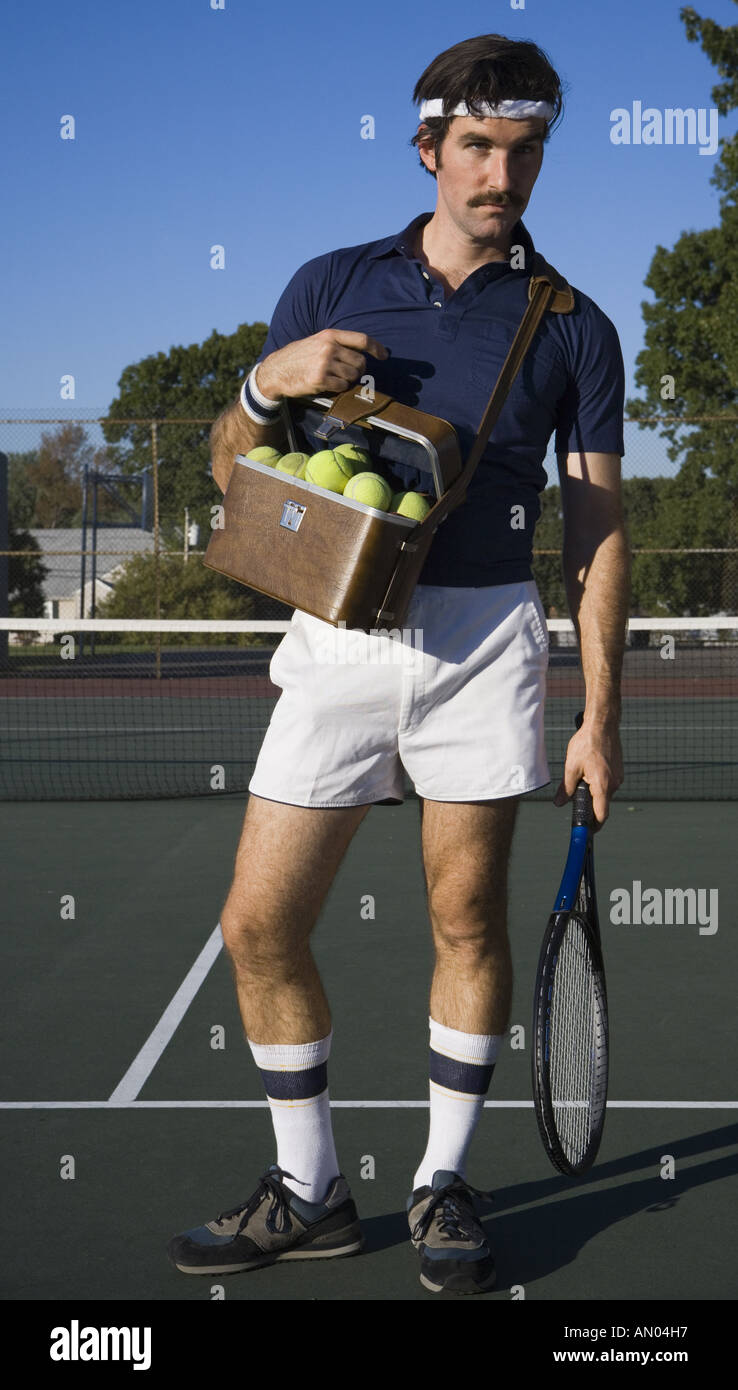 Young man holding tennis balls and a tennis racket Stock Photo - Alamy