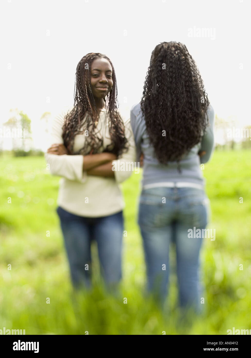 Two teenage girls standing side by side in a field Stock Photo - Alamy