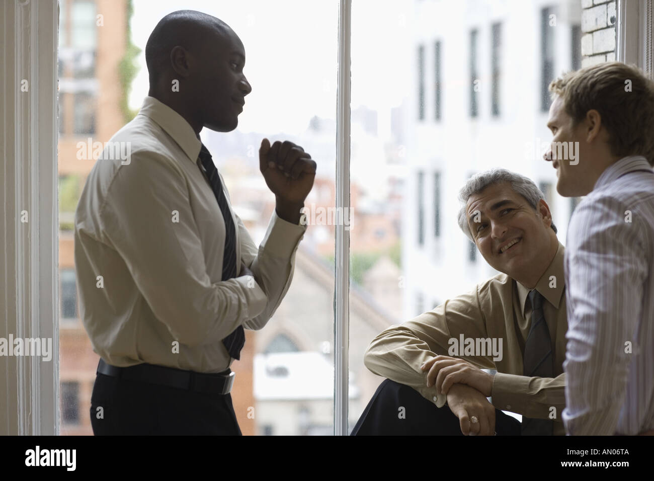 Three businessmen talking with each other Stock Photo - Alamy