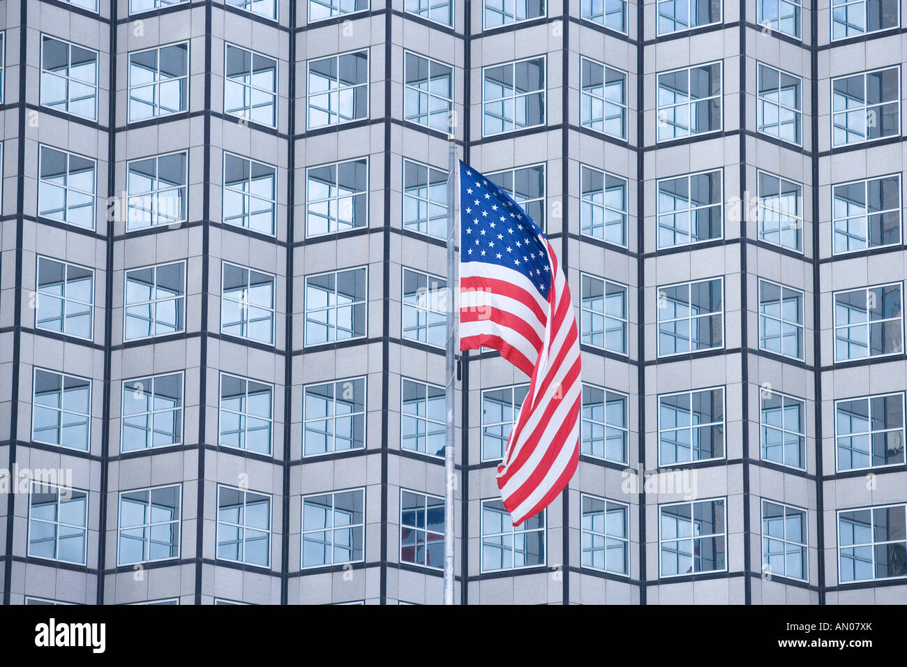 american flag flying with building behind Stock Photo - Alamy