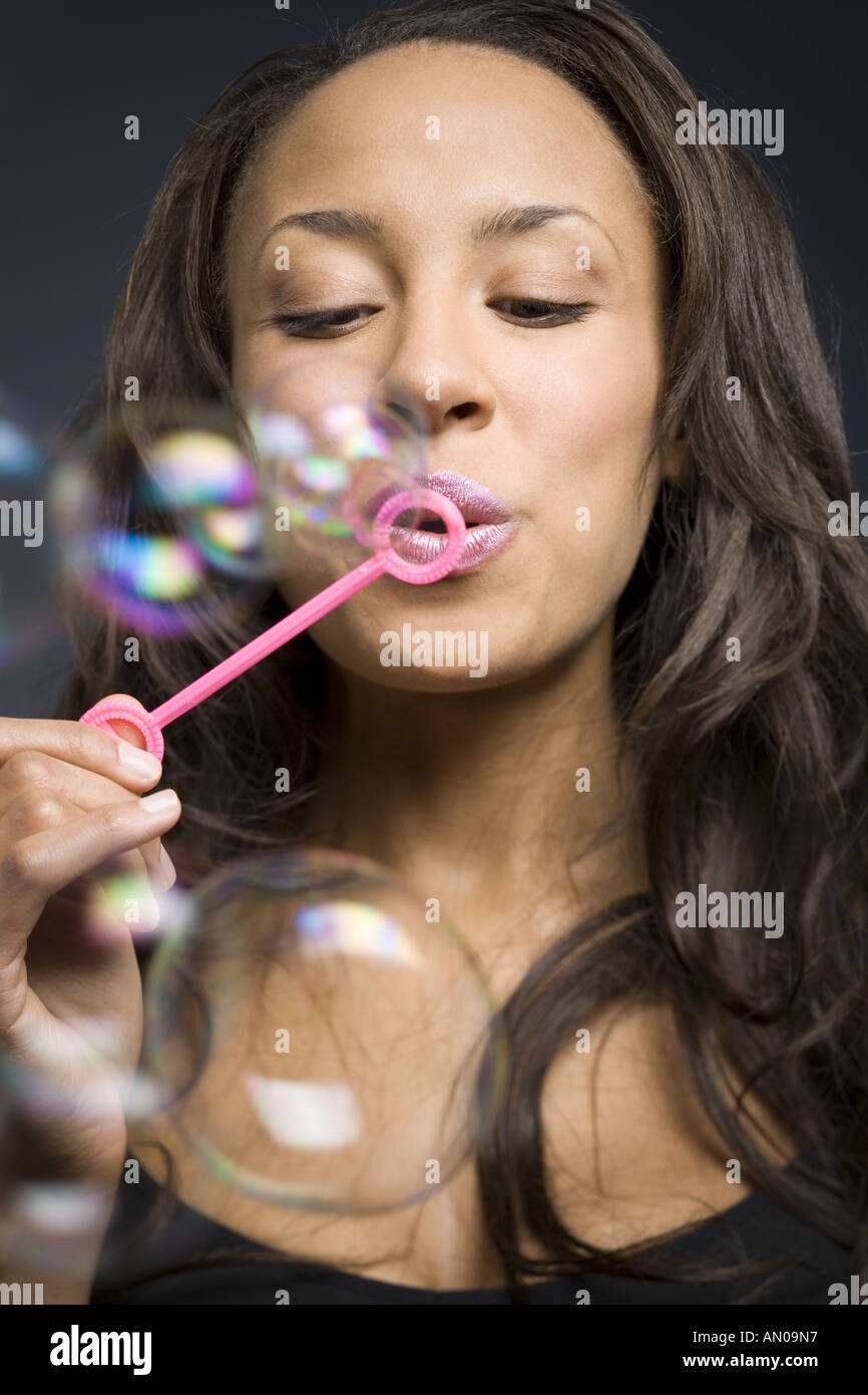 Close up of a young woman blowing bubbles through a bubble wand Stock ...