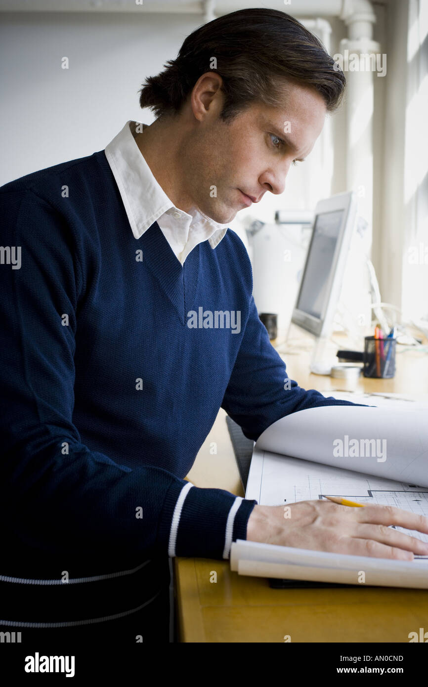 Profile of an architect looking over blueprints Stock Photo - Alamy