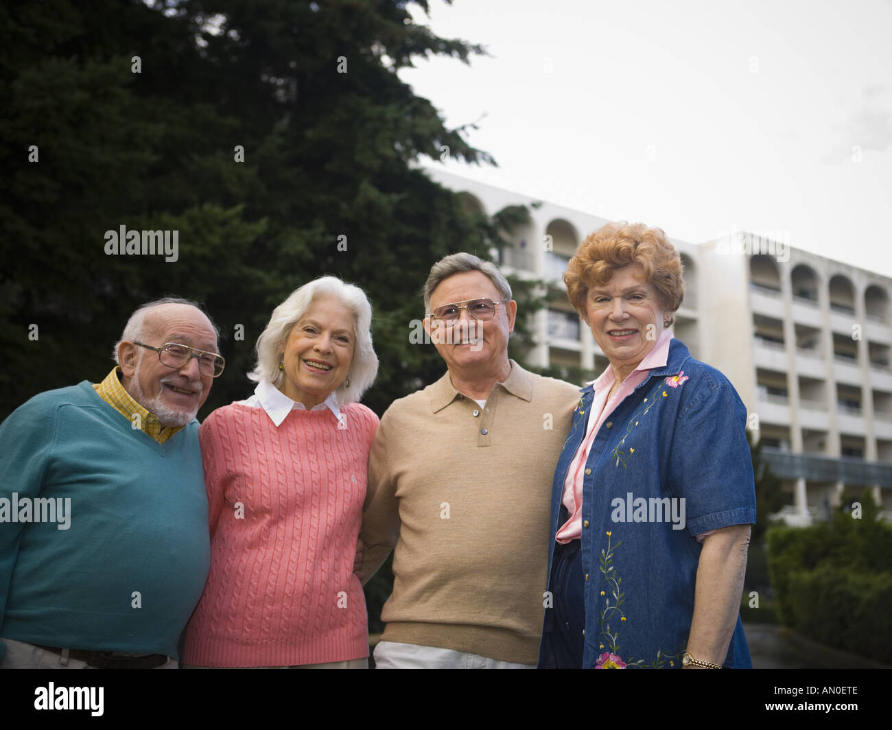 Portrait of two senior couples smiling together with their arms around ...