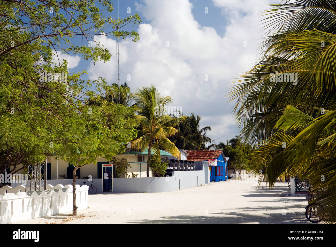 Maldives Addu Atoll Hulhudhoo Midu town main street man in phone booth ...