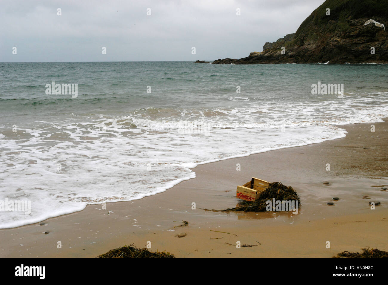 Empty wooden crate washed up on the sea shore at Greve de Lecq beach on ...