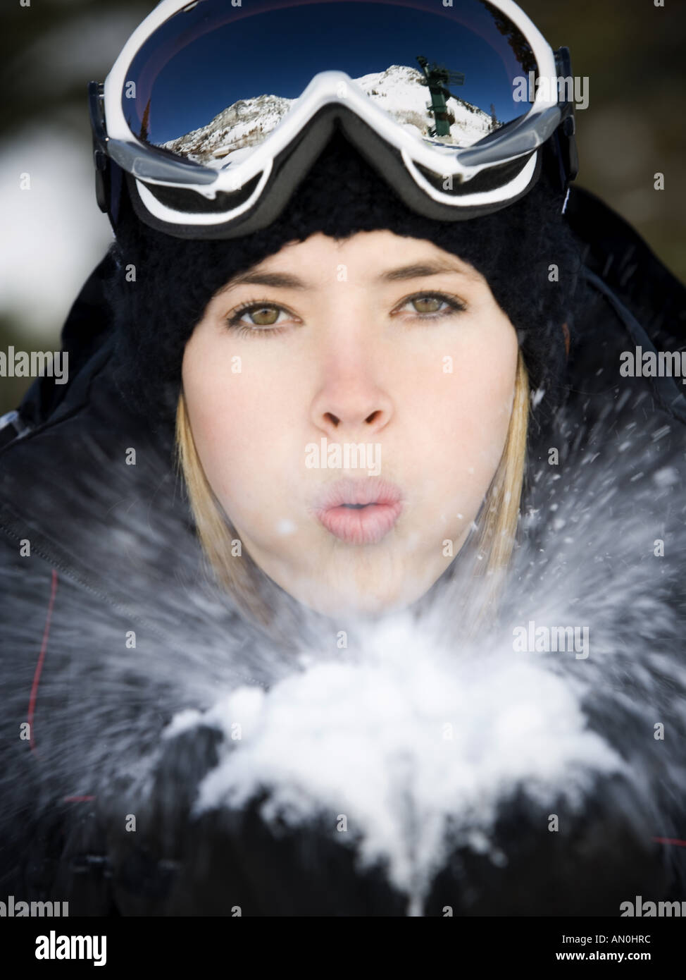 Portrait of a young woman blowing snow Stock Photo - Alamy