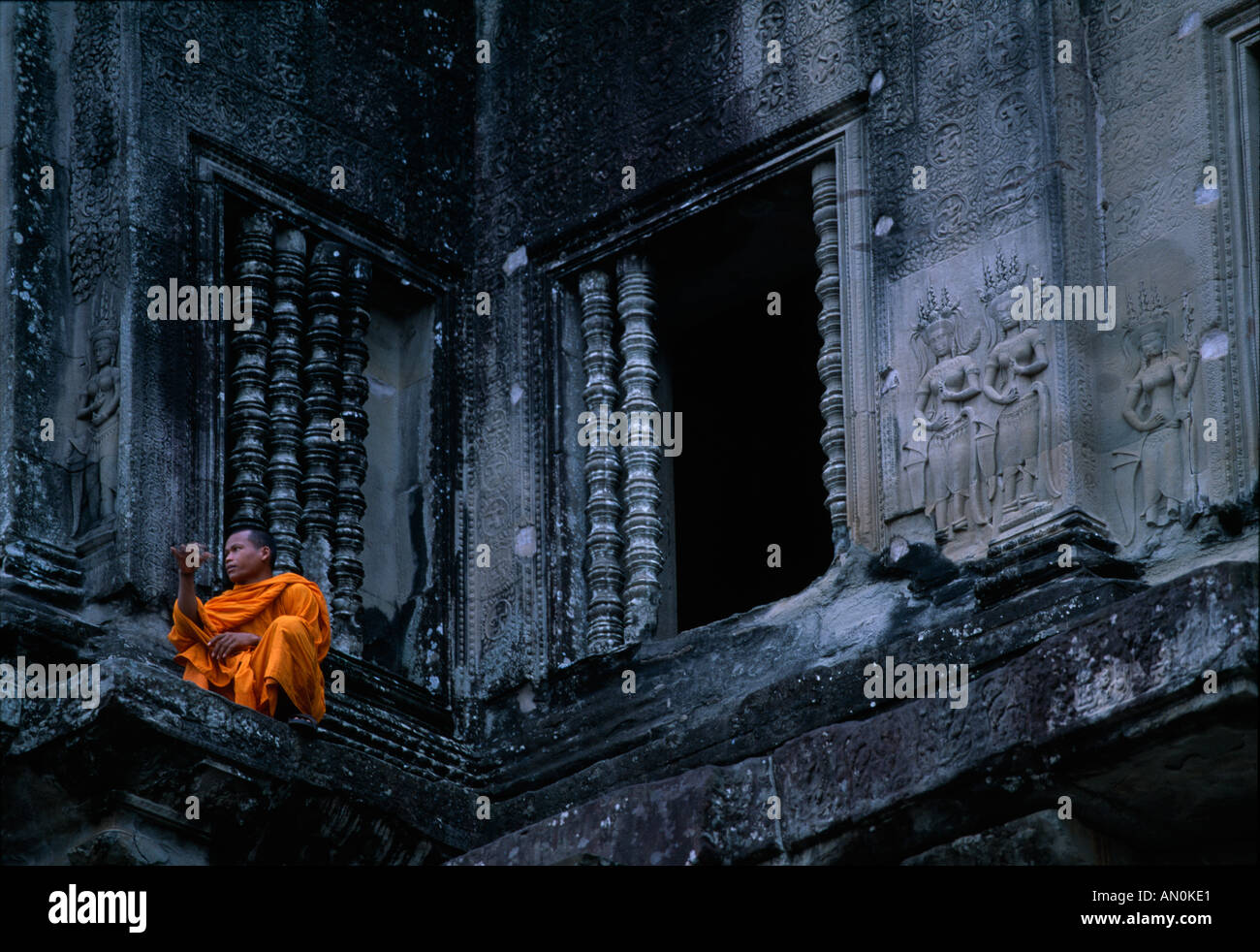 Cambodia Angkor Wat Buddhist monk sits on steep stone walls of Angkor ...